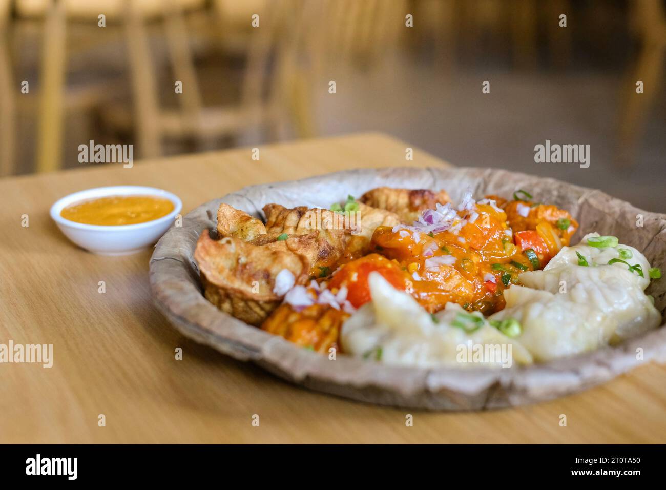 A plate of assorted chicken momos (steamed, fried and chilli sauce ...