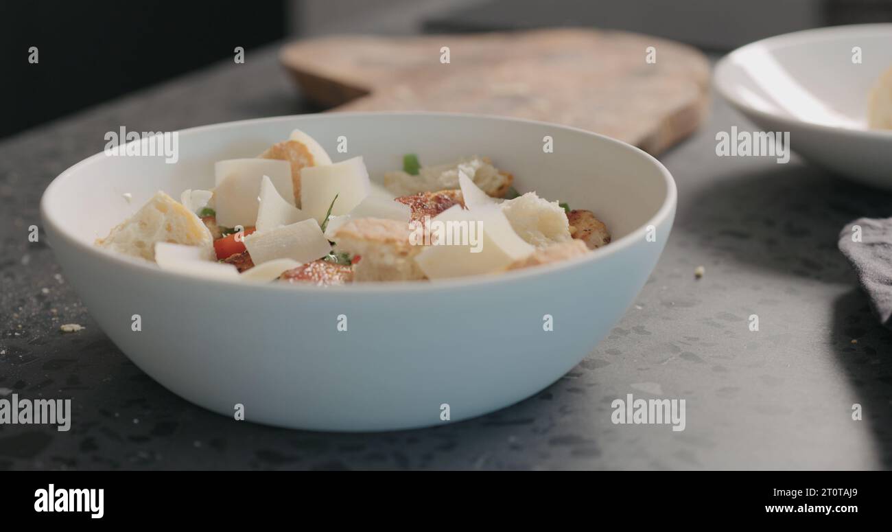 Closeup shot of caesar salad in a bowl on kitchen countertop, shallow ...