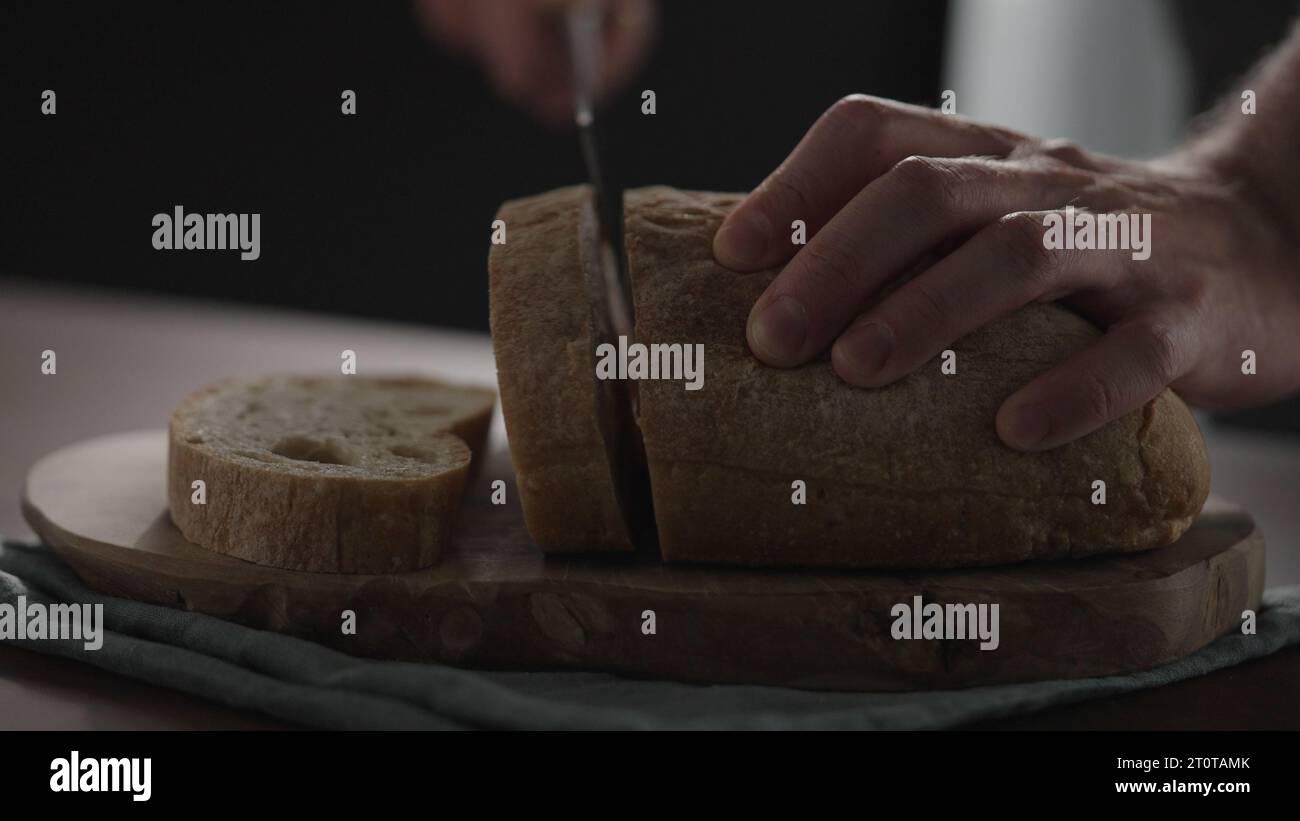 man hand slicing ciabatta on olive board, shallow focus Stock Photo - Alamy