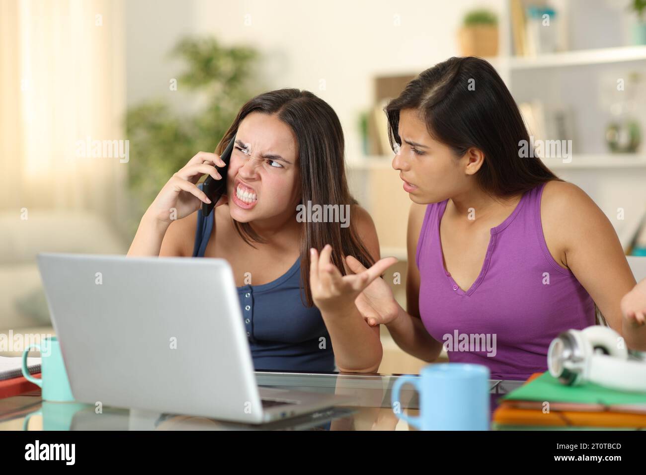 Two angry students claiming talking on phone at home Stock Photo - Alamy