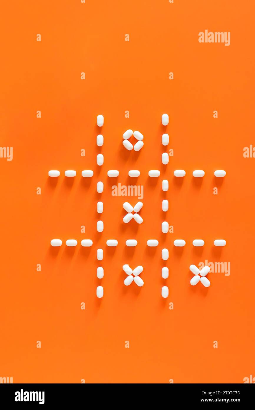 A top view of white candies as a Tic-Tac-Toe game on an orange ...