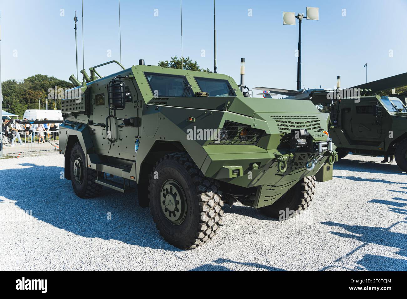 Outdoor shot of dark green modern military vehicle parked in the middle ...