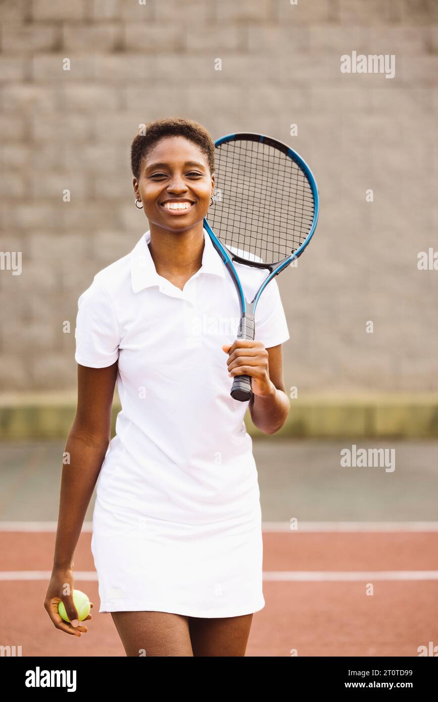 Portrait of a young beautiful women with tennis clothes and racket in a ...