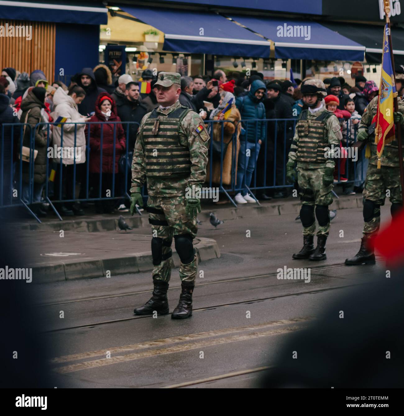A group of uniformed servicemen stand in formation, holding national ...