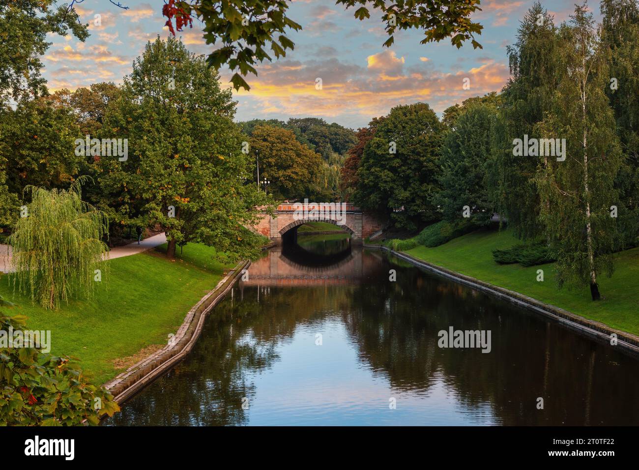 View of the water canal and bridge among trees at the urban park in ...