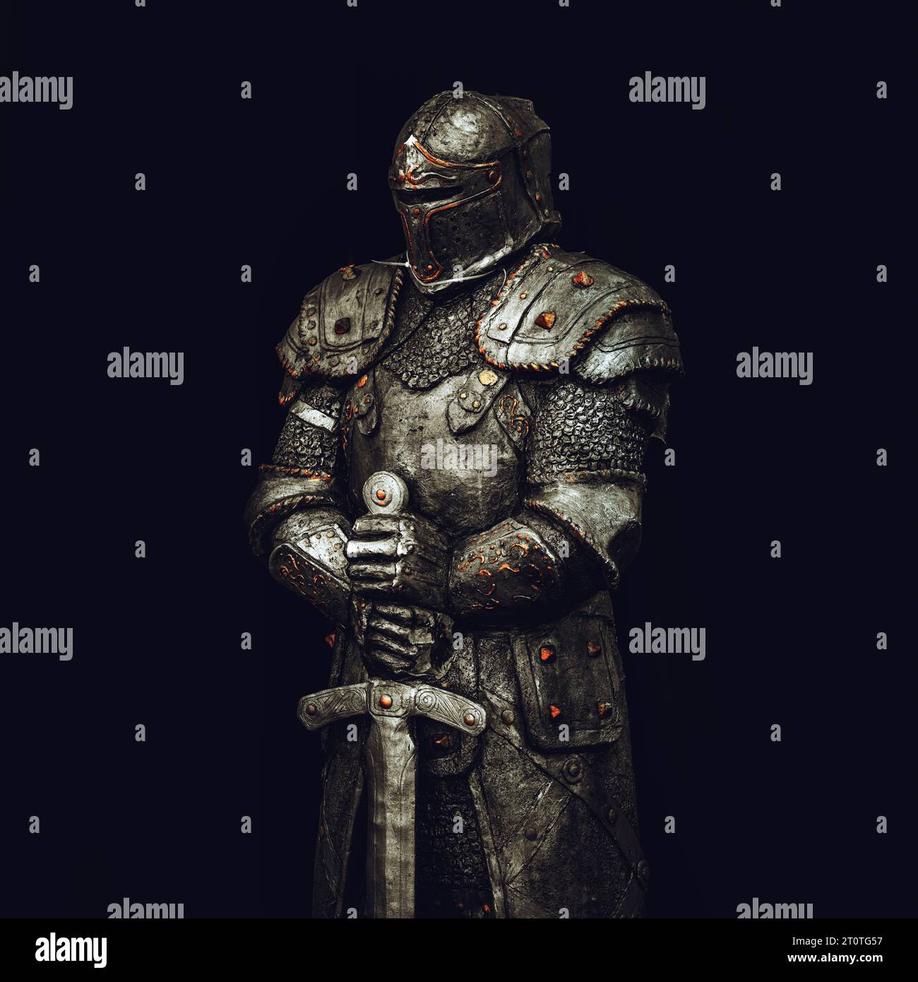Statue of medieval knight in metal armor with a sword, isolated on dark ...