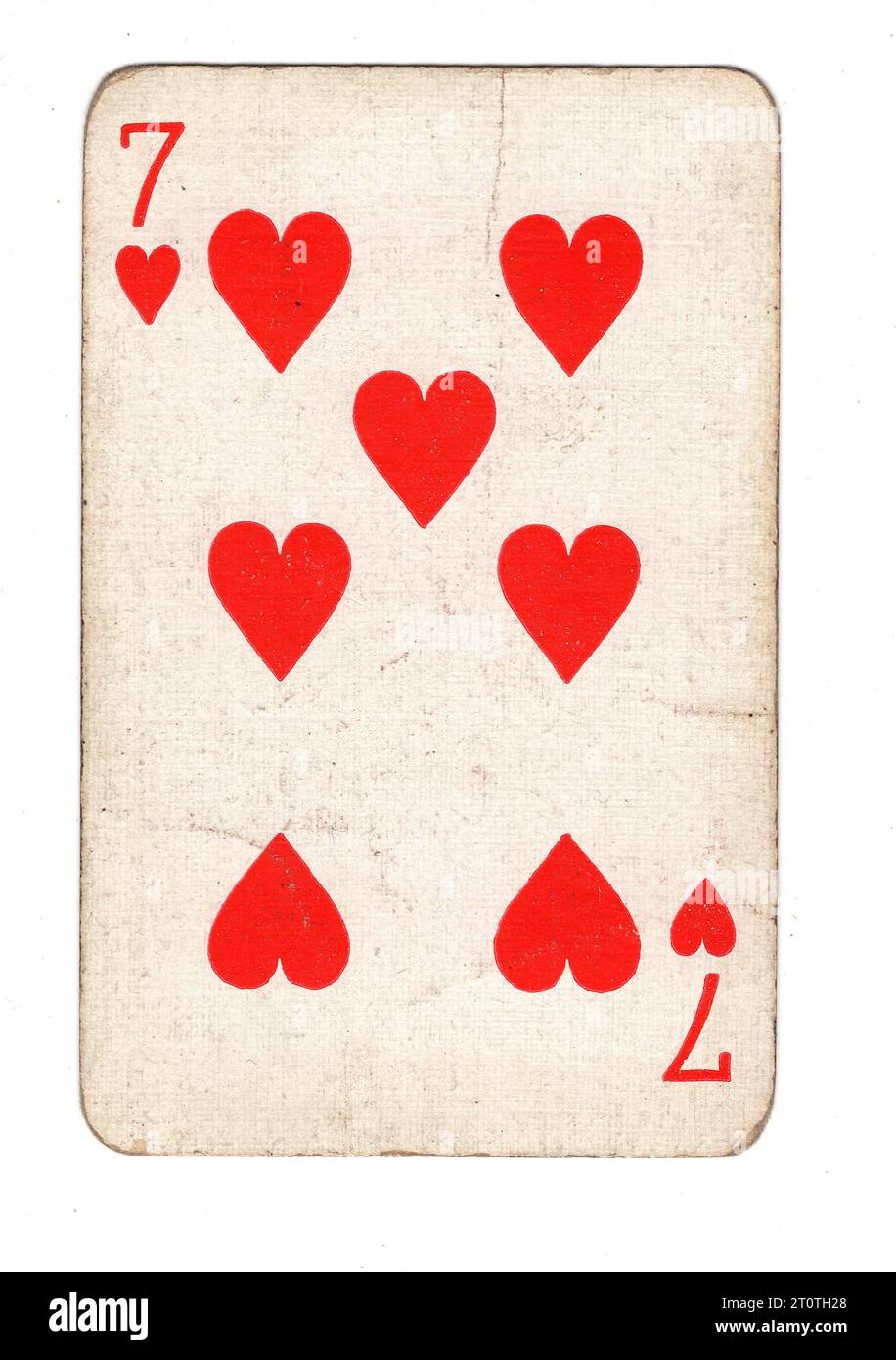 A vintage seven of hearts playing card isolated on a white background ...