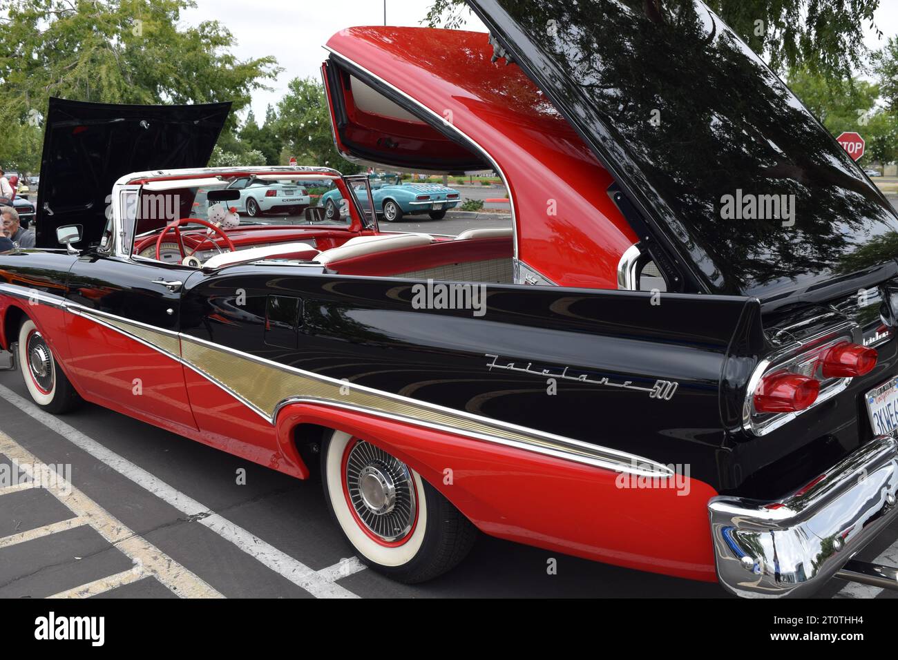 A classic red and black Chevy pickup truck is seen parked in a lot ...