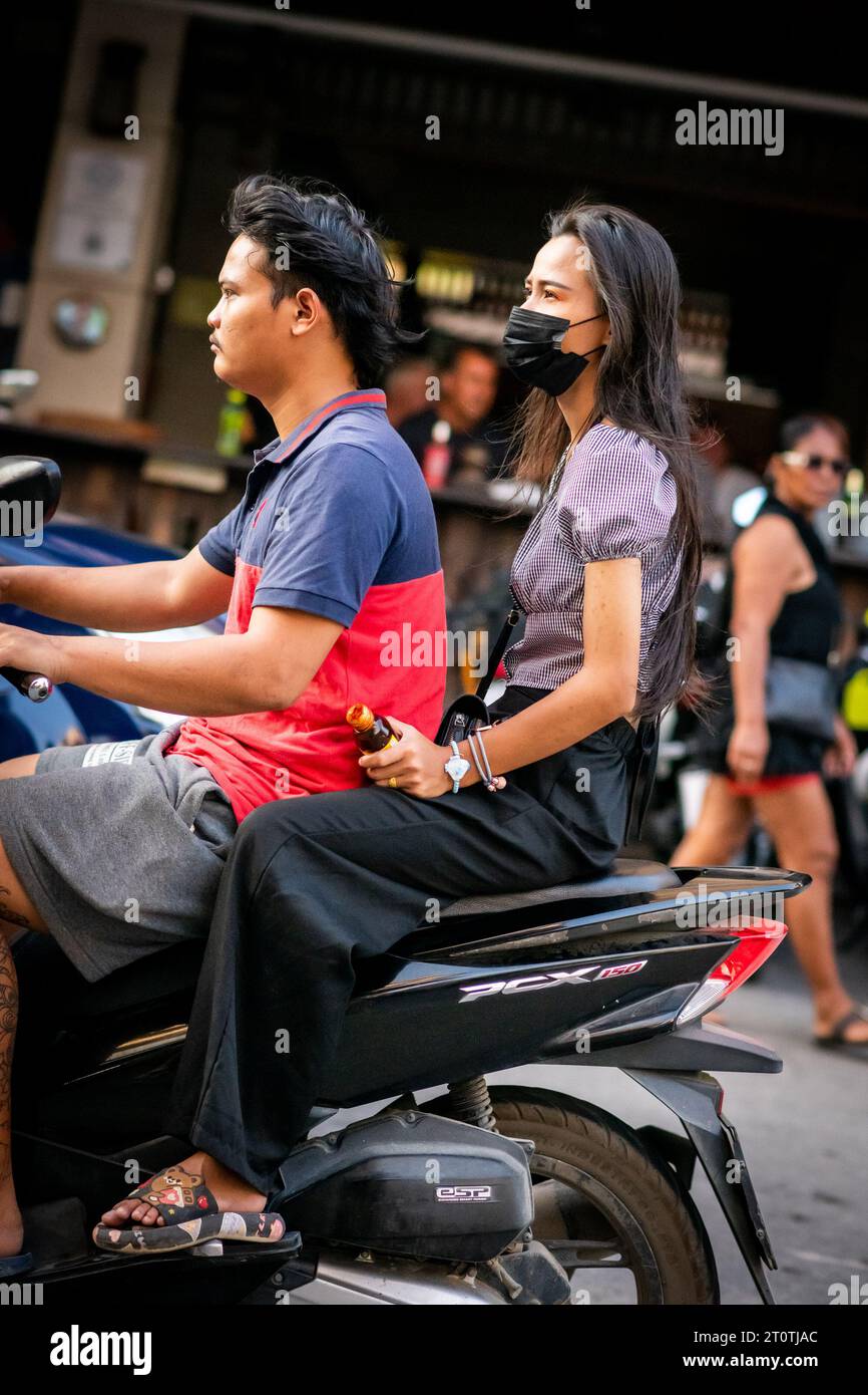 Local Thai people, tourists and residents rush past the busy junction ...