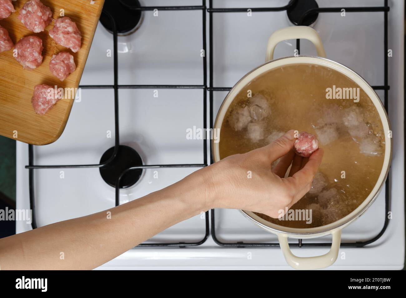 Top view of female hand dropping meatballs in boiling water Stock Photo ...