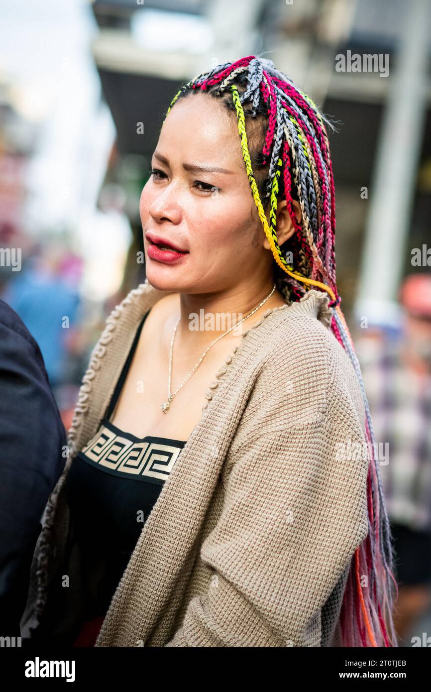 Local Thai people, tourists and residents rush past the busy junction ...