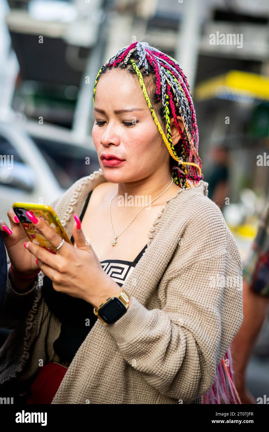 Local Thai people, tourists and residents rush past the busy junction ...