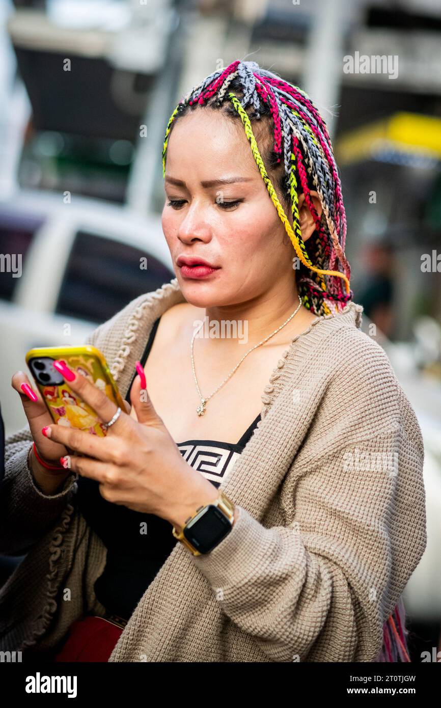 Local Thai people, tourists and residents rush past the busy junction ...