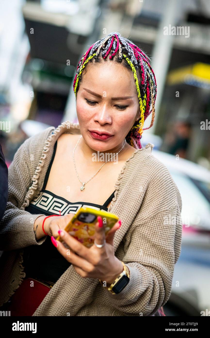 Local Thai people, tourists and residents rush past the busy junction ...