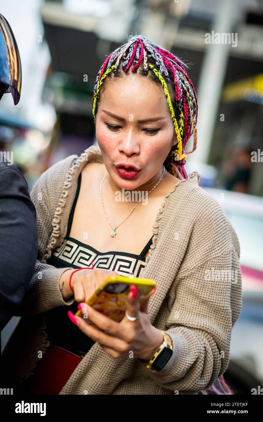 Local Thai people, tourists and residents rush past the busy junction ...