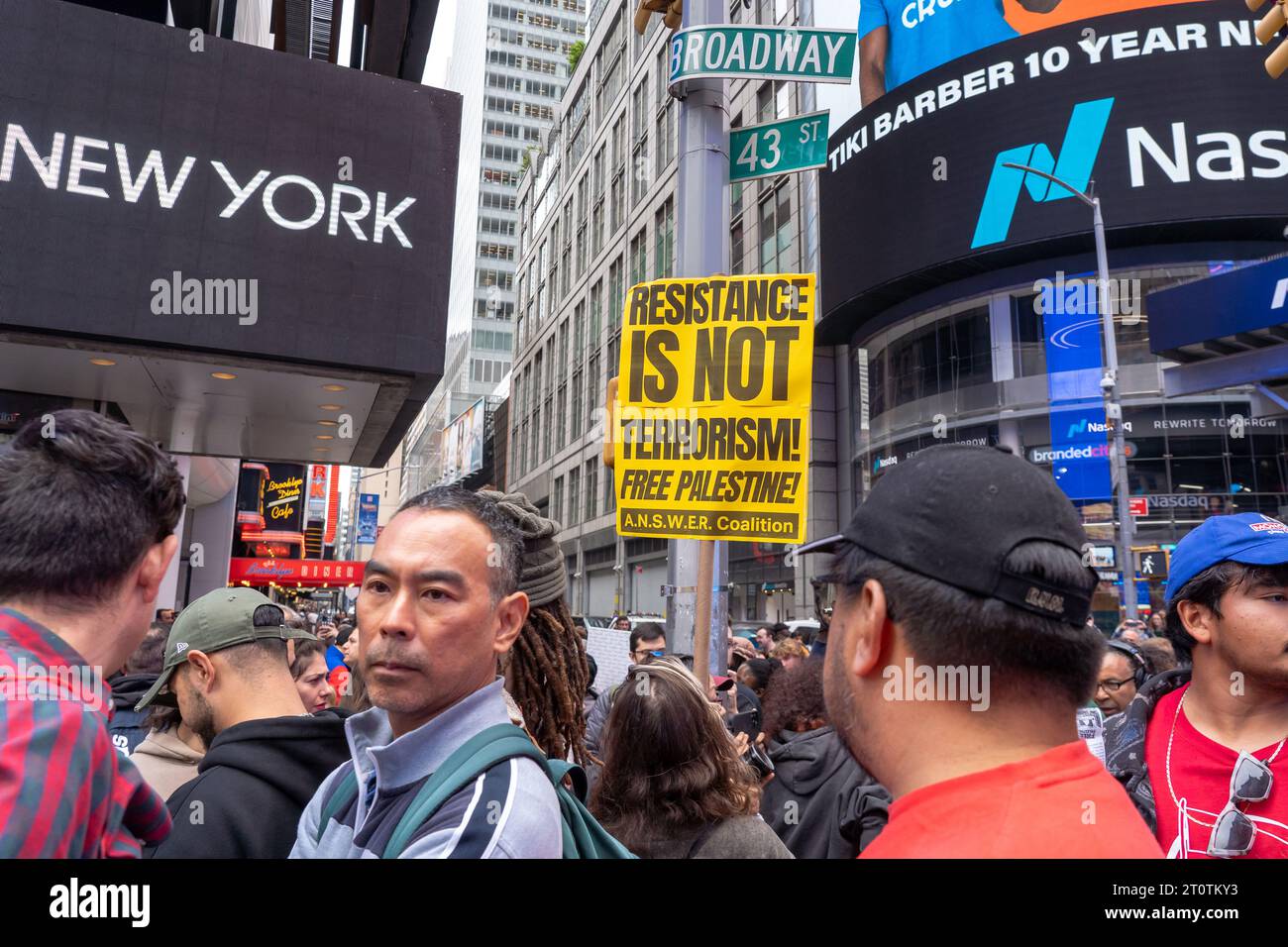 A woman holds a "resistance is not terrorism" sign at a rally in ...