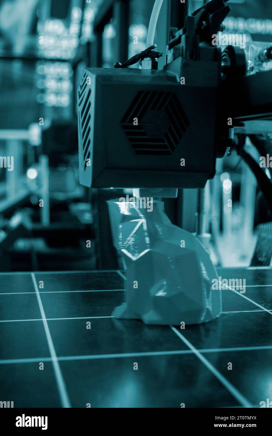 3D printer printing prototype of toy from molten plastic. Process of ...