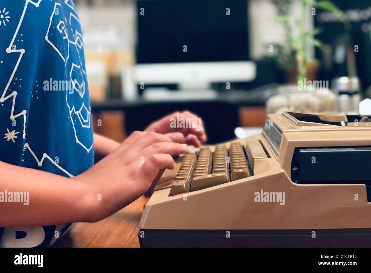 Boy types on a vintage typewriter Stock Photo - Alamy