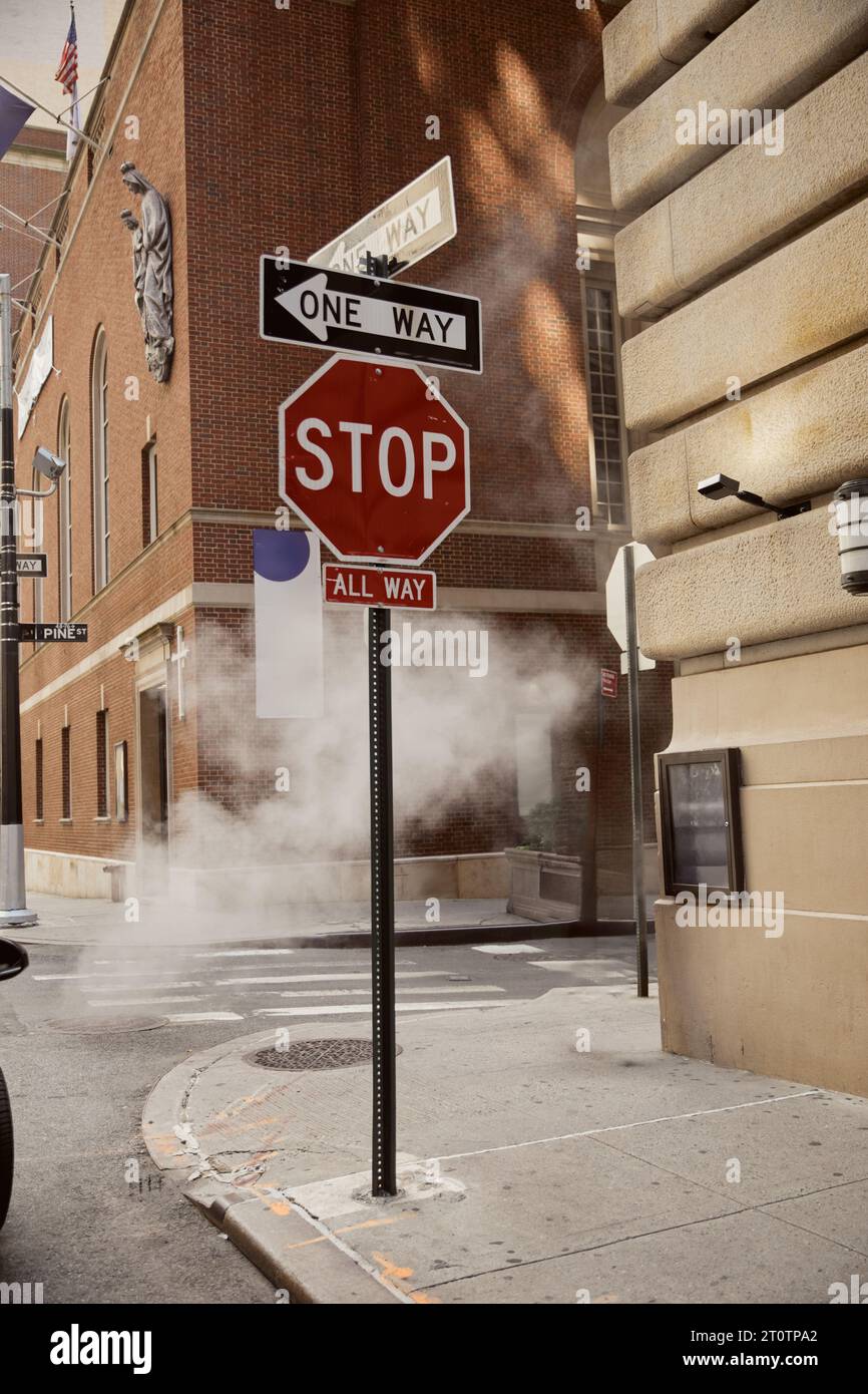 steam near road signs and vintage buildings in downtown of new york ...