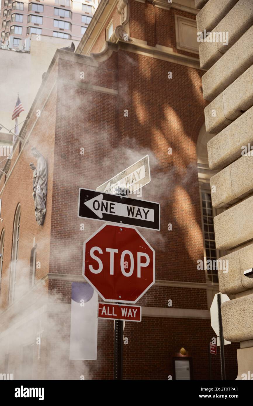 road signs near steam and vintage buildings on street of new york city ...