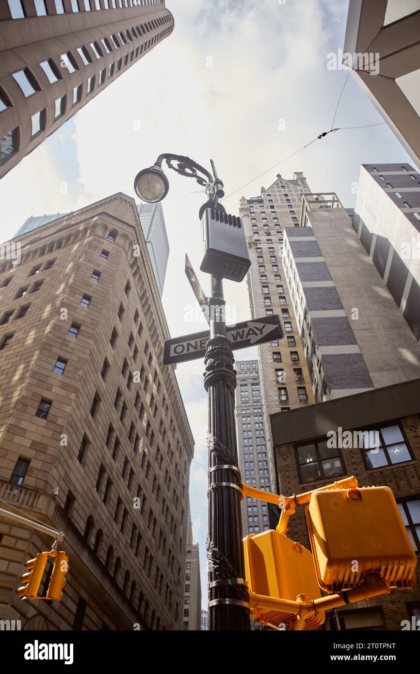 low angle view of street pole with road signs and traffic lights near ...