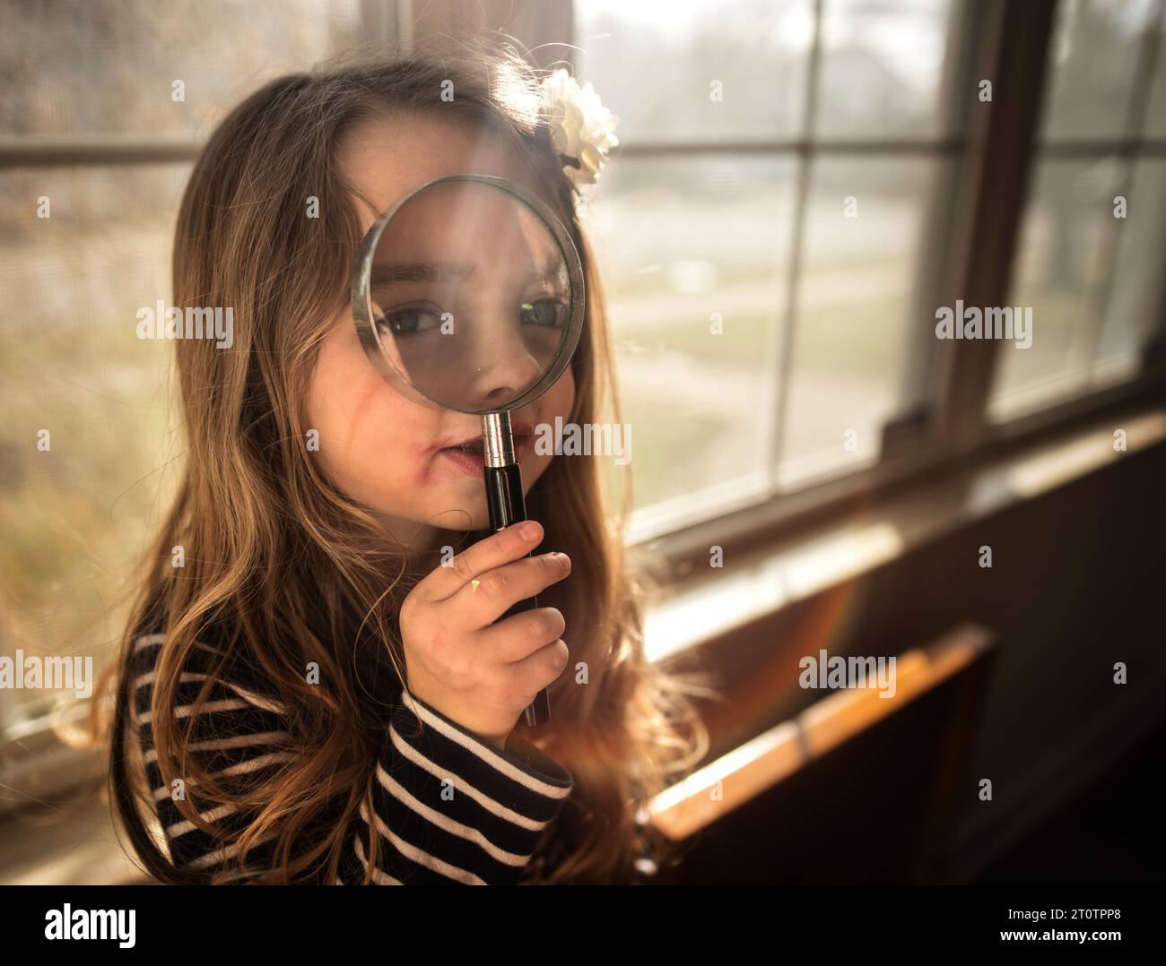 Little girl looking through magnifying glass Stock Photo - Alamy