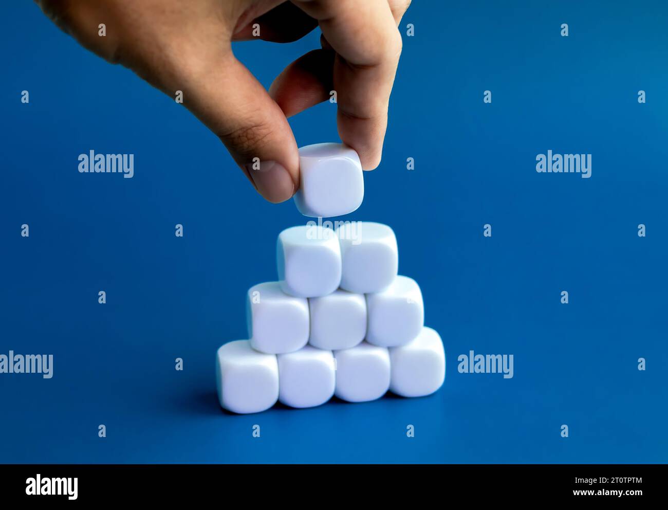 Empty blank white dice block in hand put on cube blocks stack pyramid ...