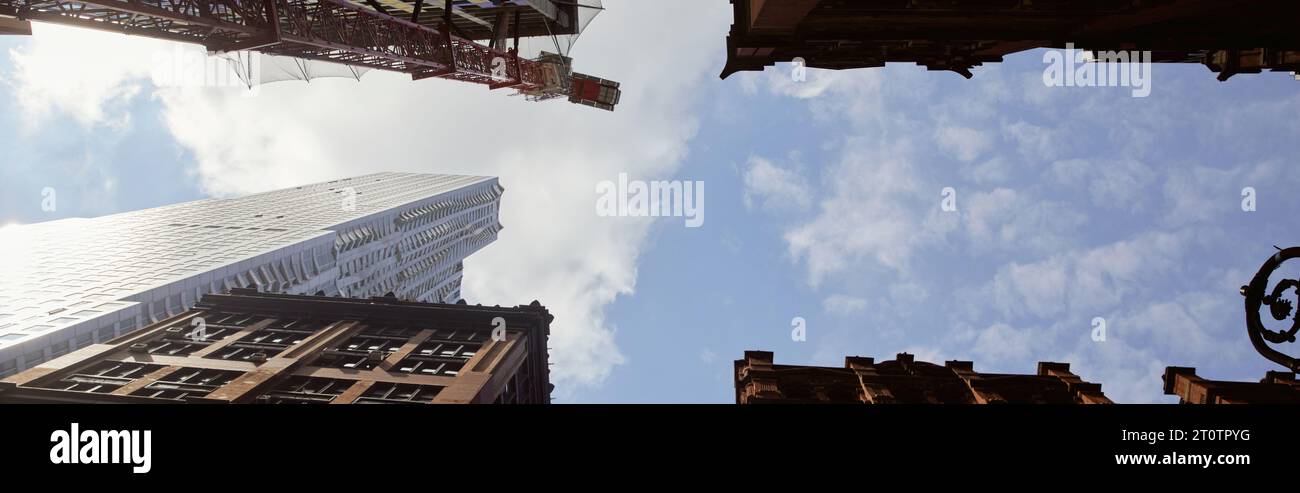 bottom view of modern and vintage buildings against blue cloudy sky in ...