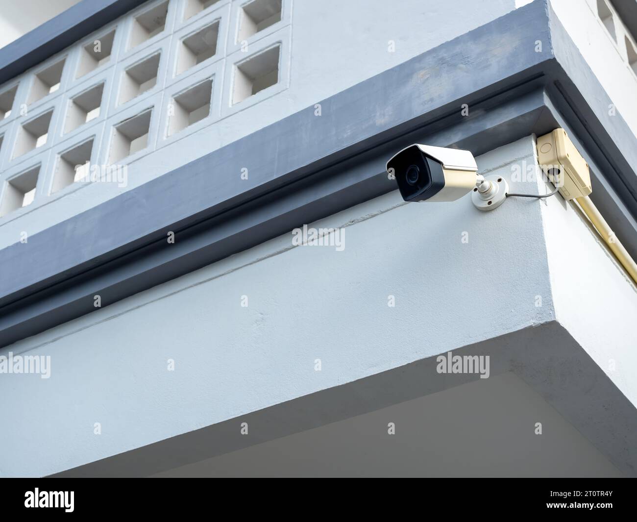 Old white CCTV camera hanging at the corner at the outdoor of modern ...
