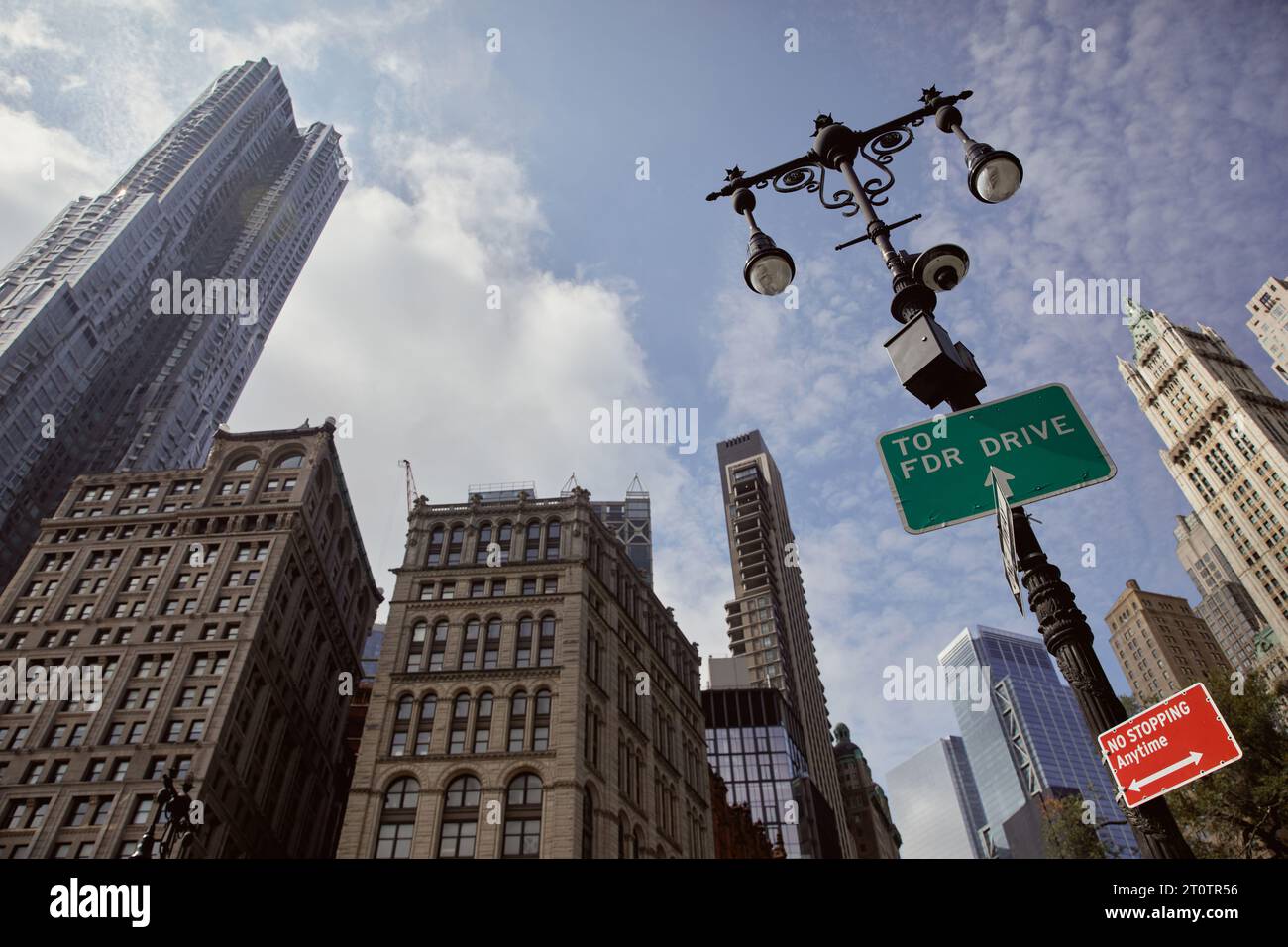 street pole with lanterns and traffic signs against skyscrapers in new ...