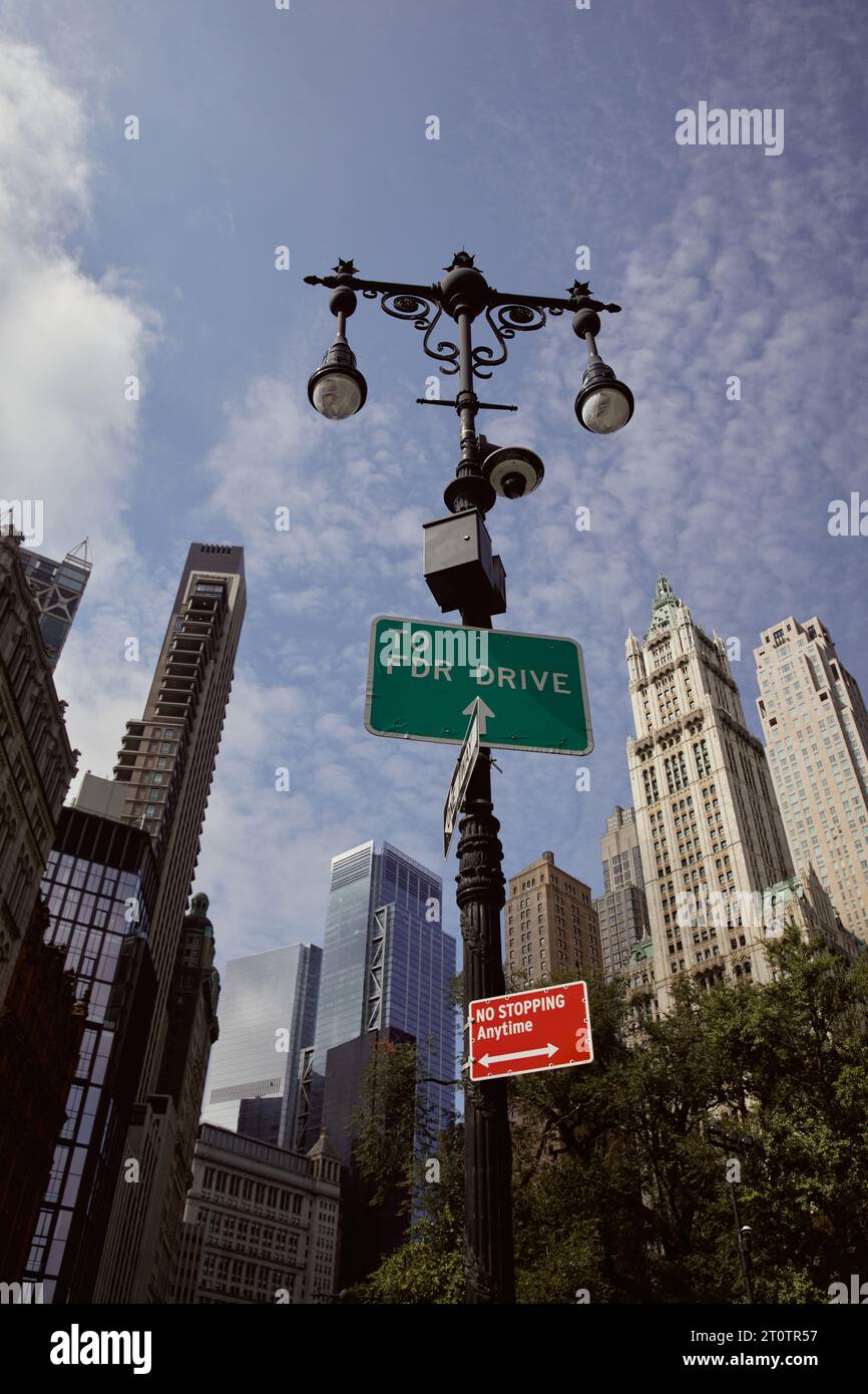 low angle view of street pole with lanterns and traffic signs against ...