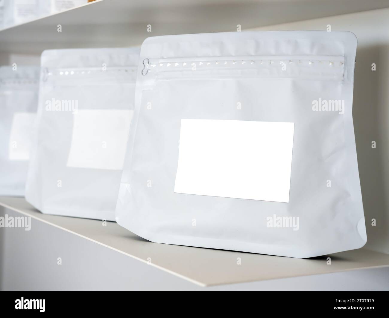 Close Up empty blank white label on modern white foil bags coffee beans ...