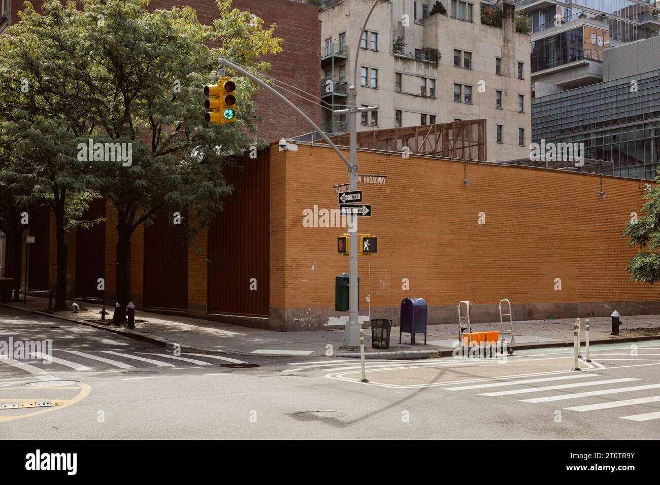 brick fence near road pole with traffic light of crossroad with ...