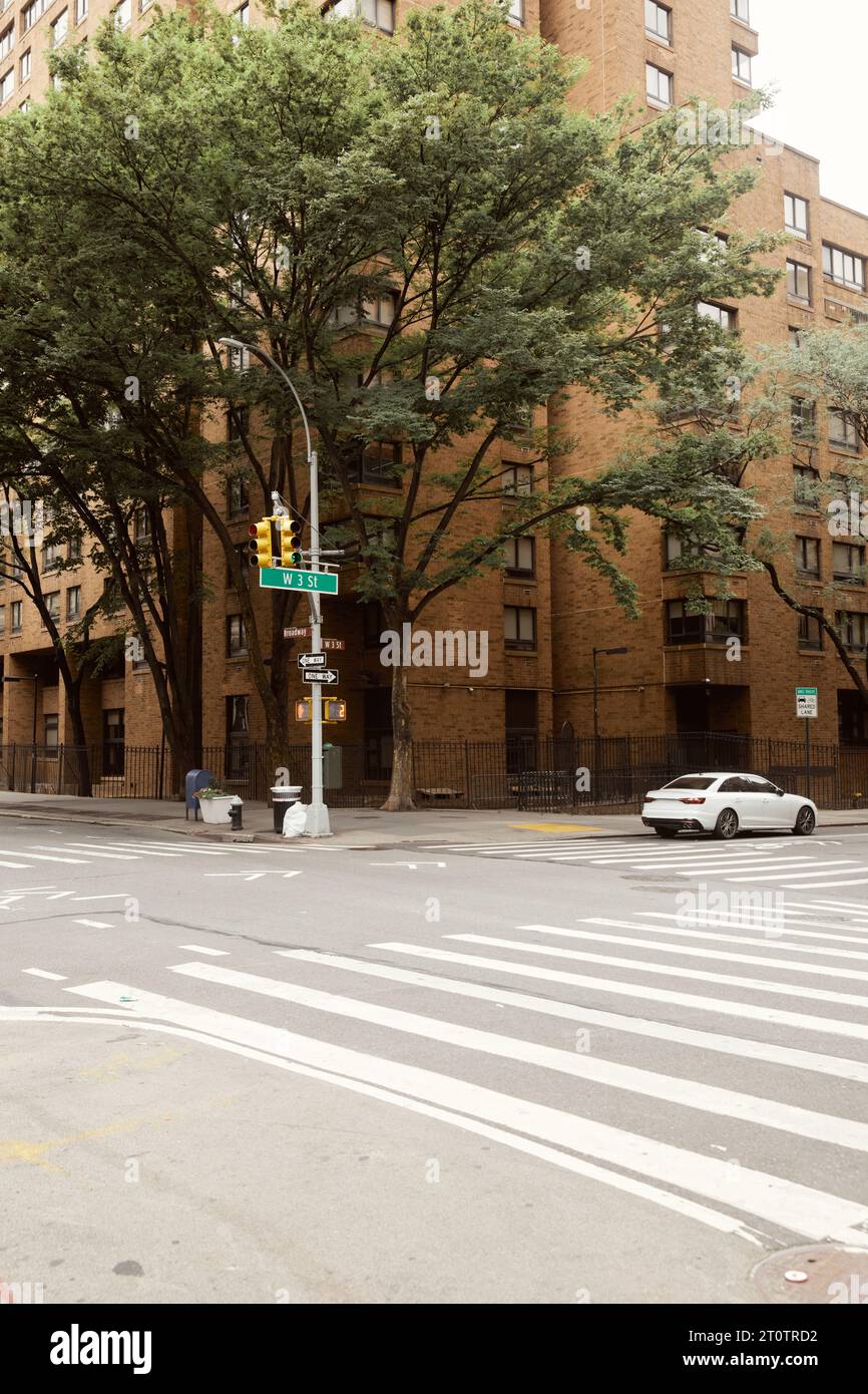 autumn trees and brick building near traffic intersection with ...