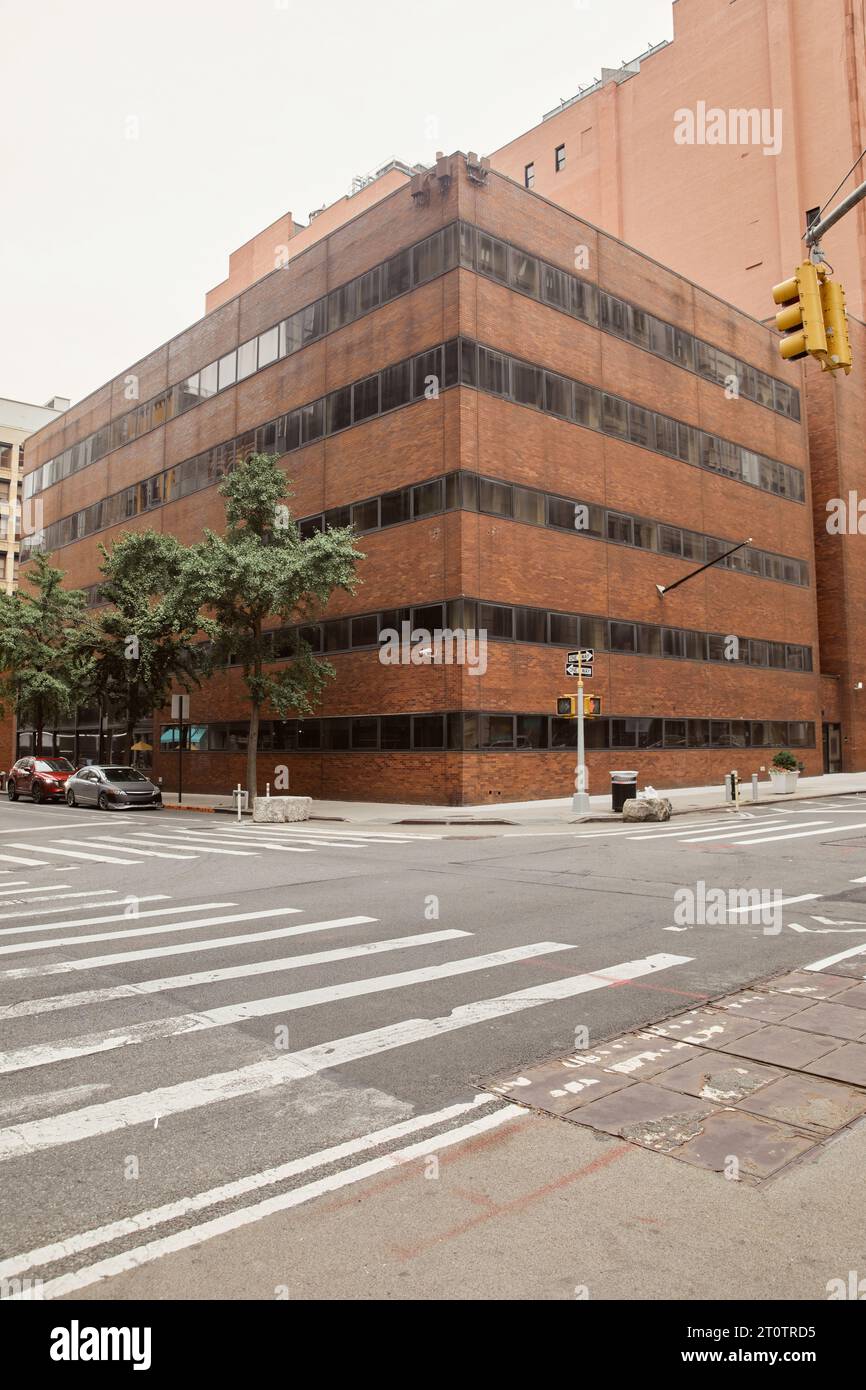modern brick building on crossroad with pedestrian crossing on urban ...