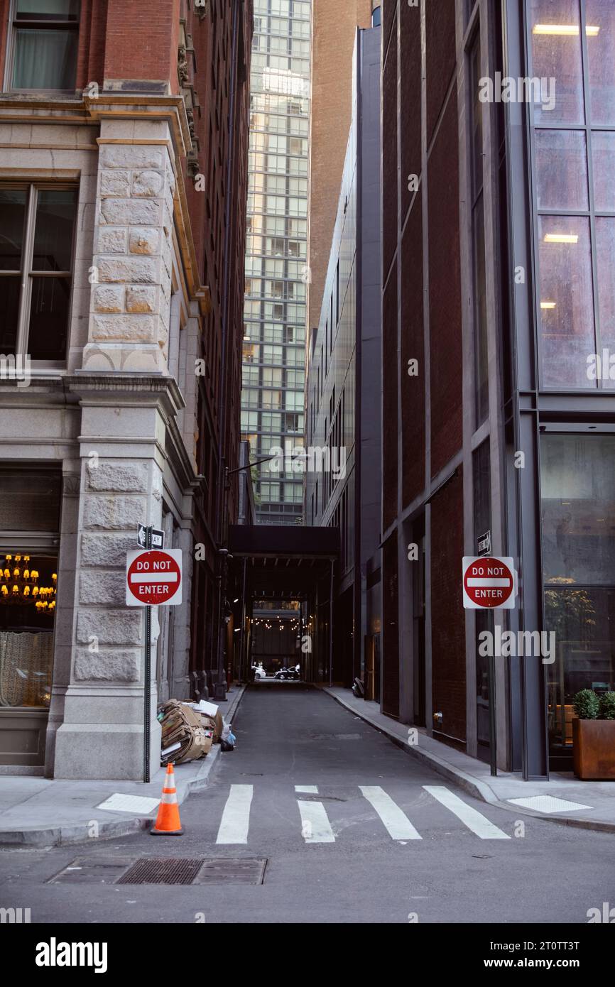 do not enter road signs between contemporary buildings on urban street ...