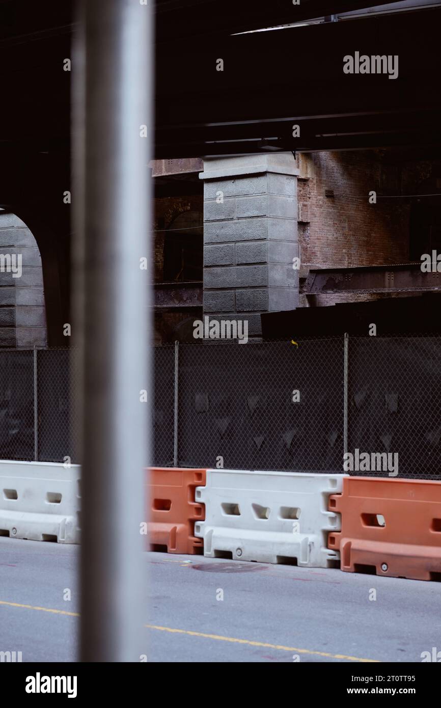 traffic roadway with plastic road barriers under bridge in new york ...
