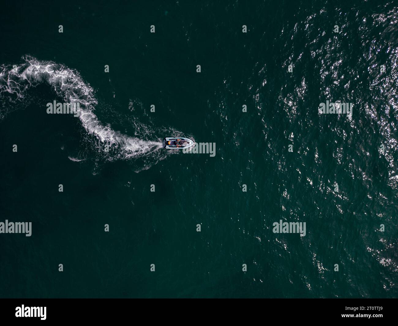 Aerial top view of a personal watercraft speeding through the waves ...