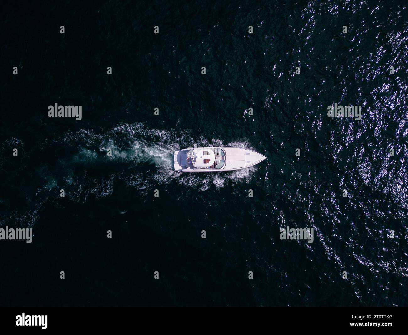Aerial drone view of a pleasure boat racing through the sea waves ...