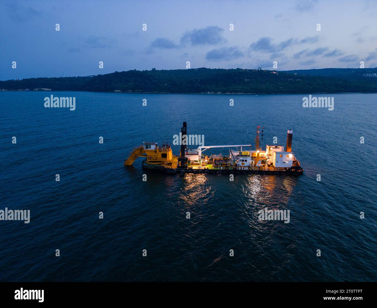 Aerial view of a dredge vessel with a dredging bucket, actively ...