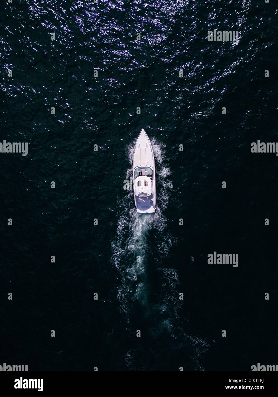 Aerial drone view of a pleasure boat racing through the sea waves ...