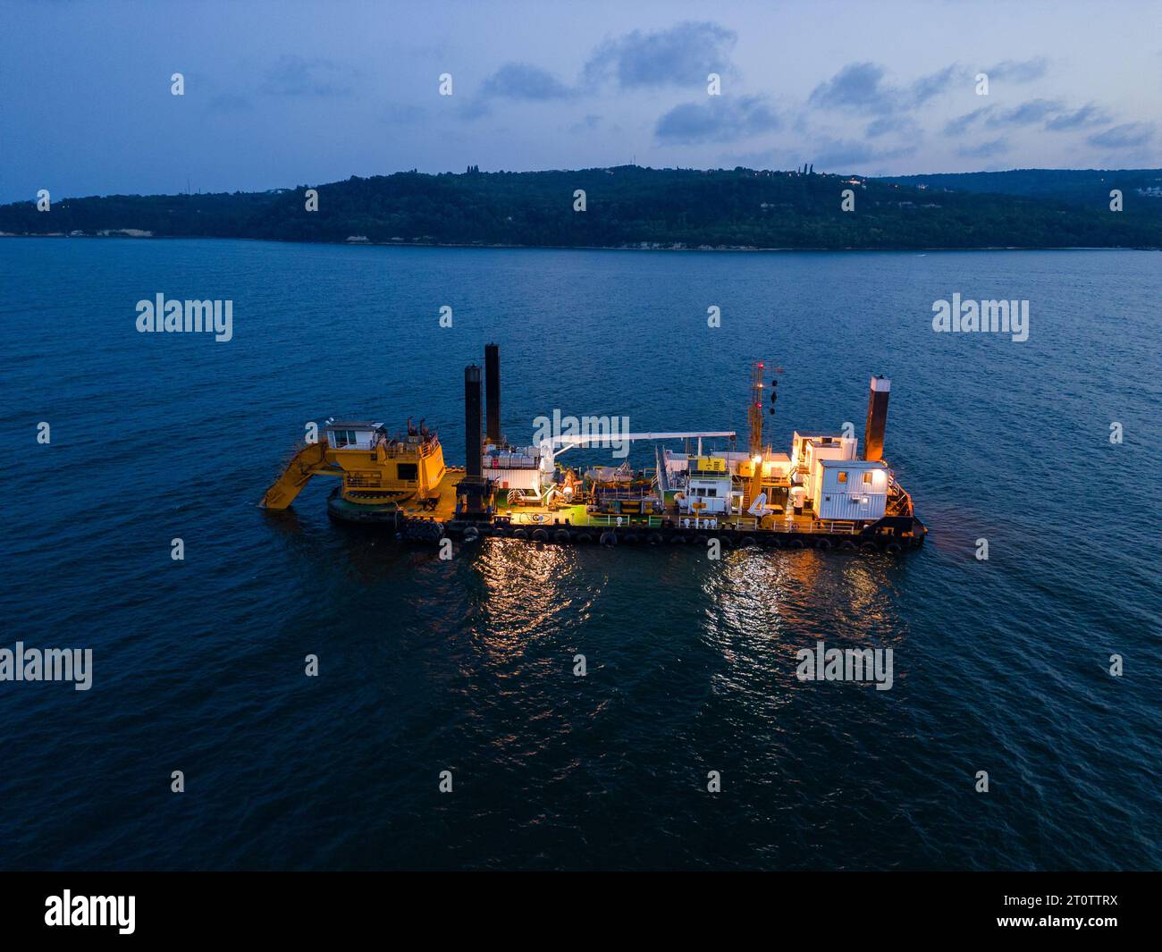 Aerial view of a dredge vessel with a dredging bucket, actively ...