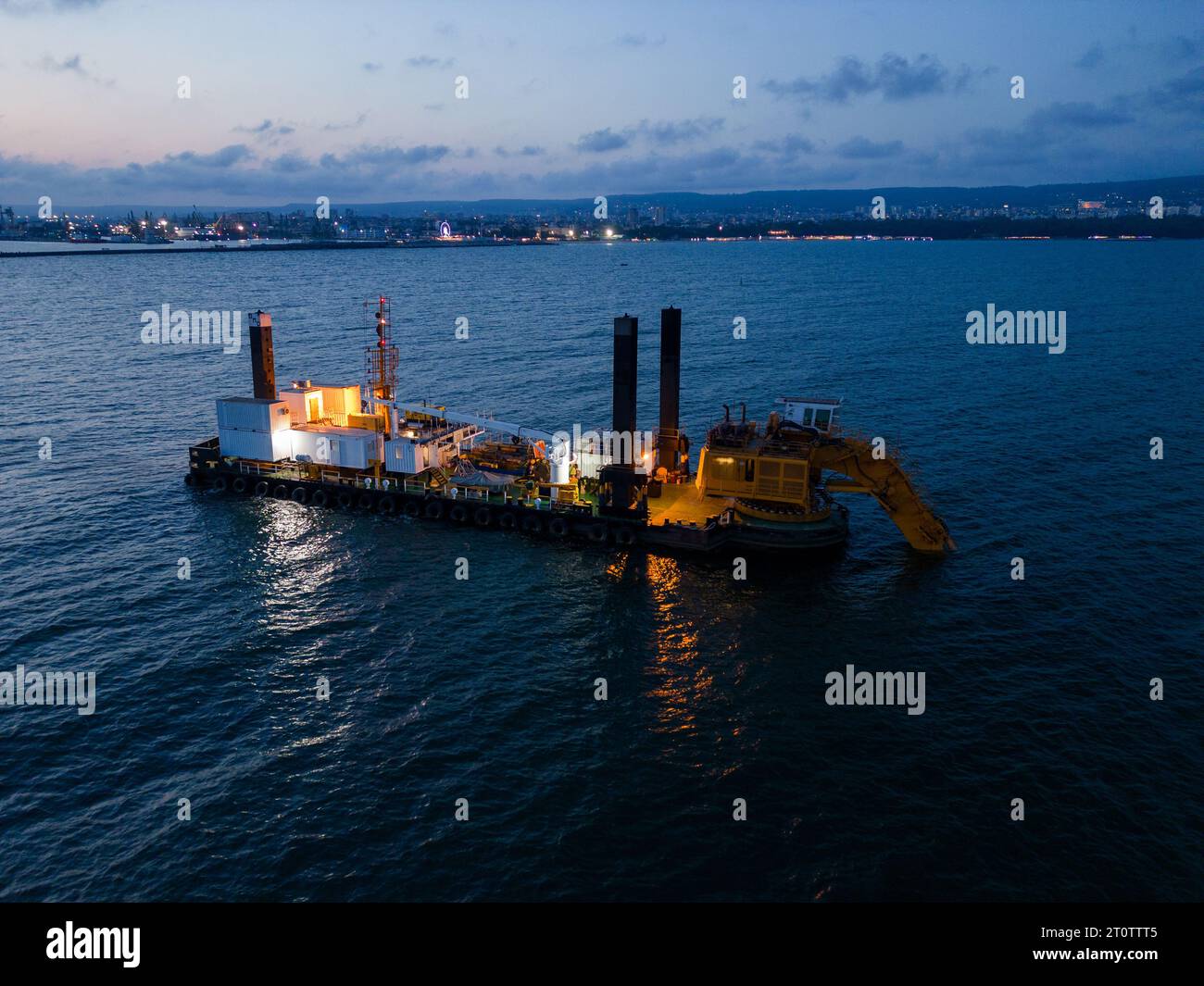 Aerial view of a dredge vessel with a dredging bucket, actively ...