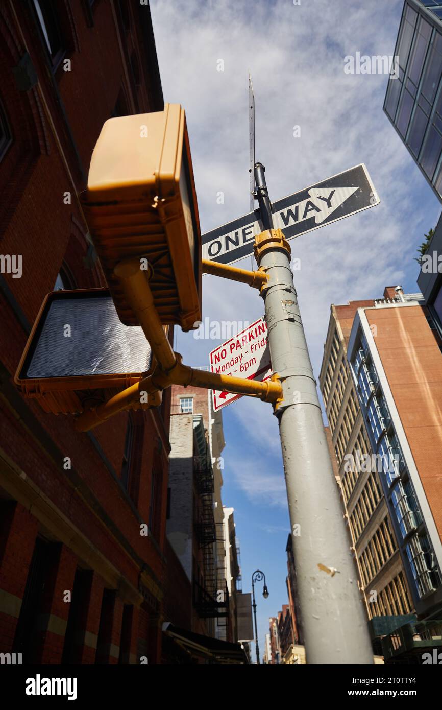 low angle view of street pole with road signs and traffic lights in new ...