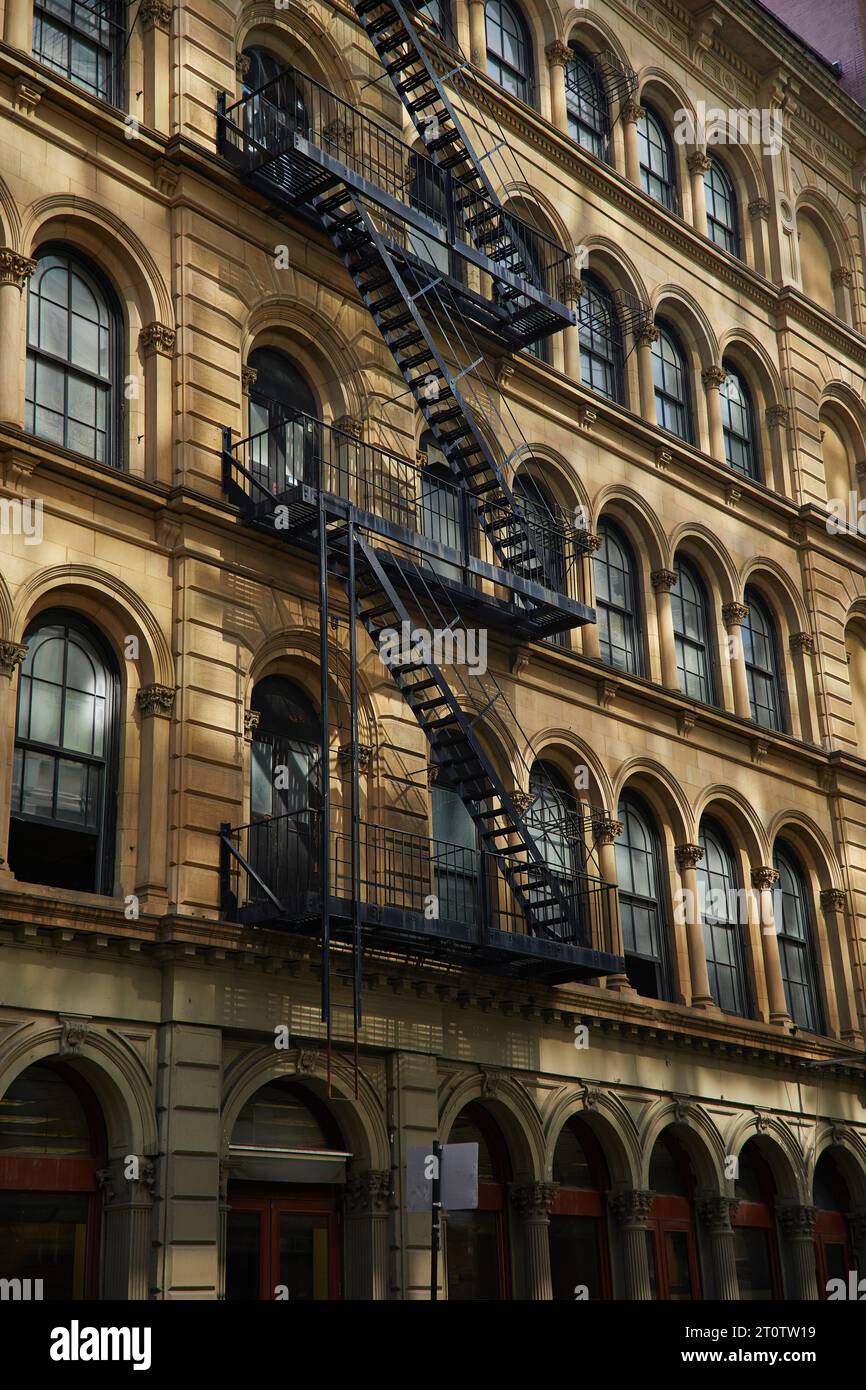 vintage building with fire escape stairs and arch windows in new york ...