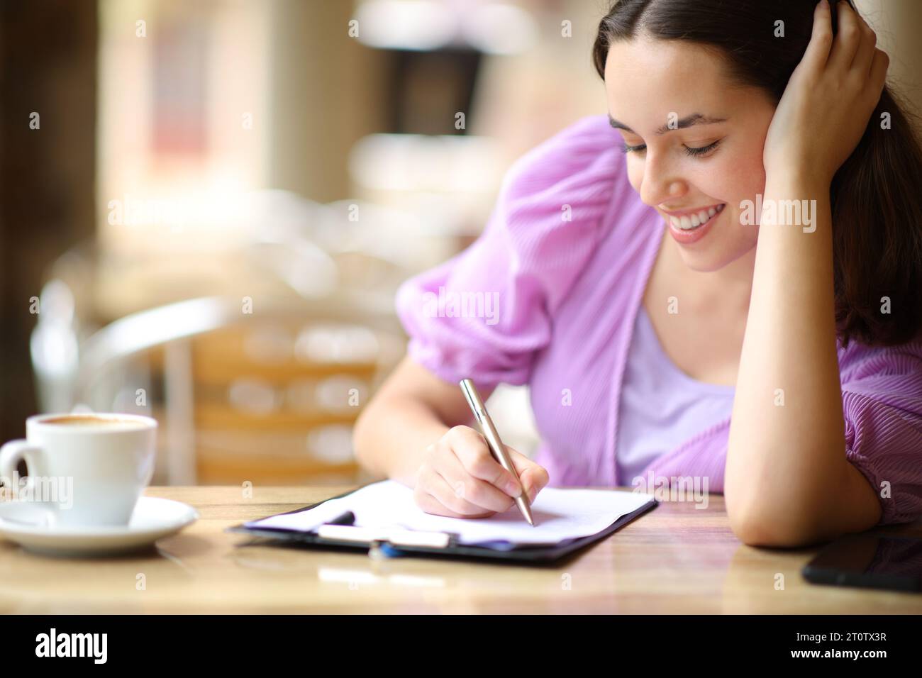 Happy woman filling survey sitting in a coffee shop terrace Stock Photo ...