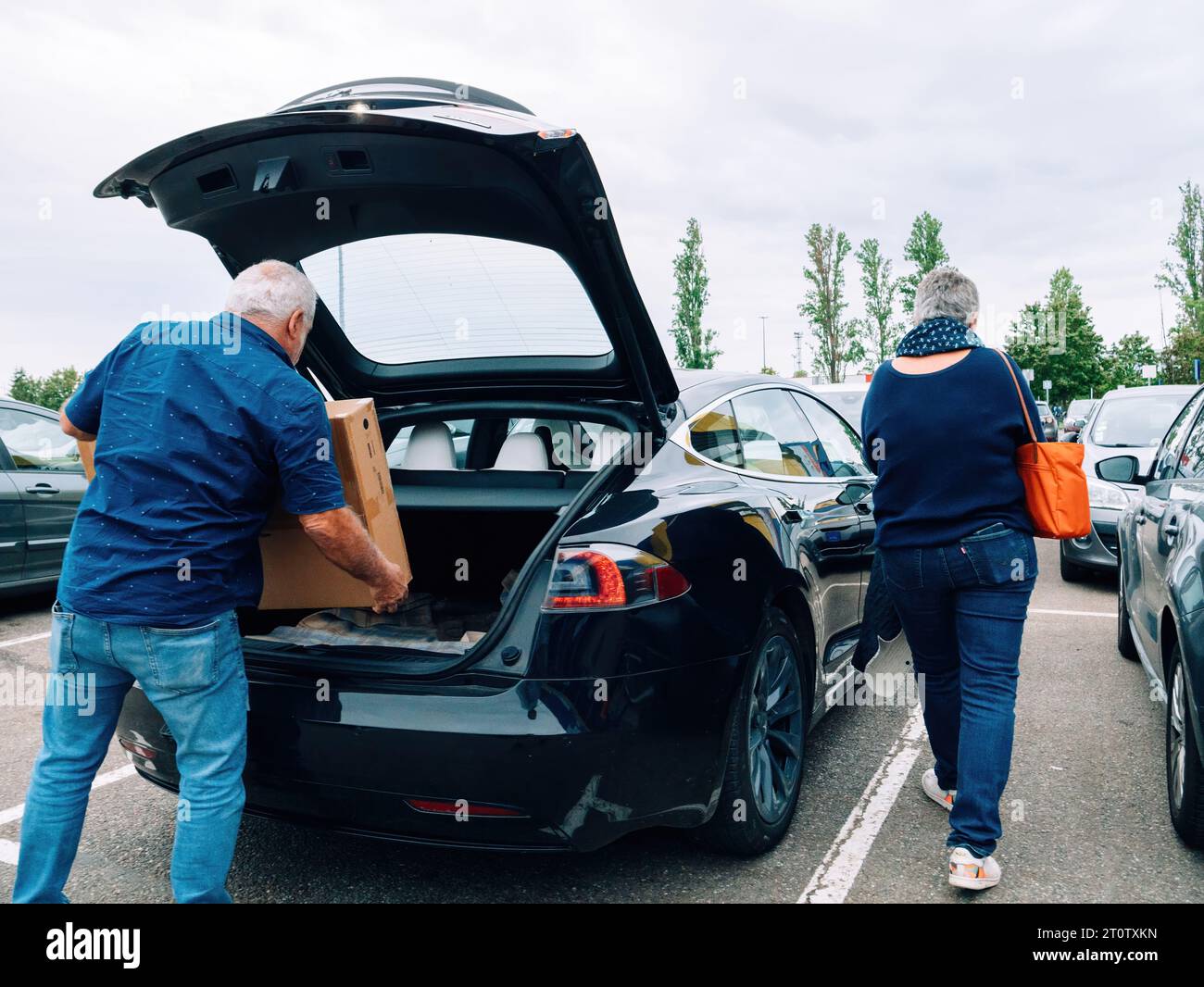 Paris, France - Aug 31, 2023: A man is seen loading a cardboard box ...