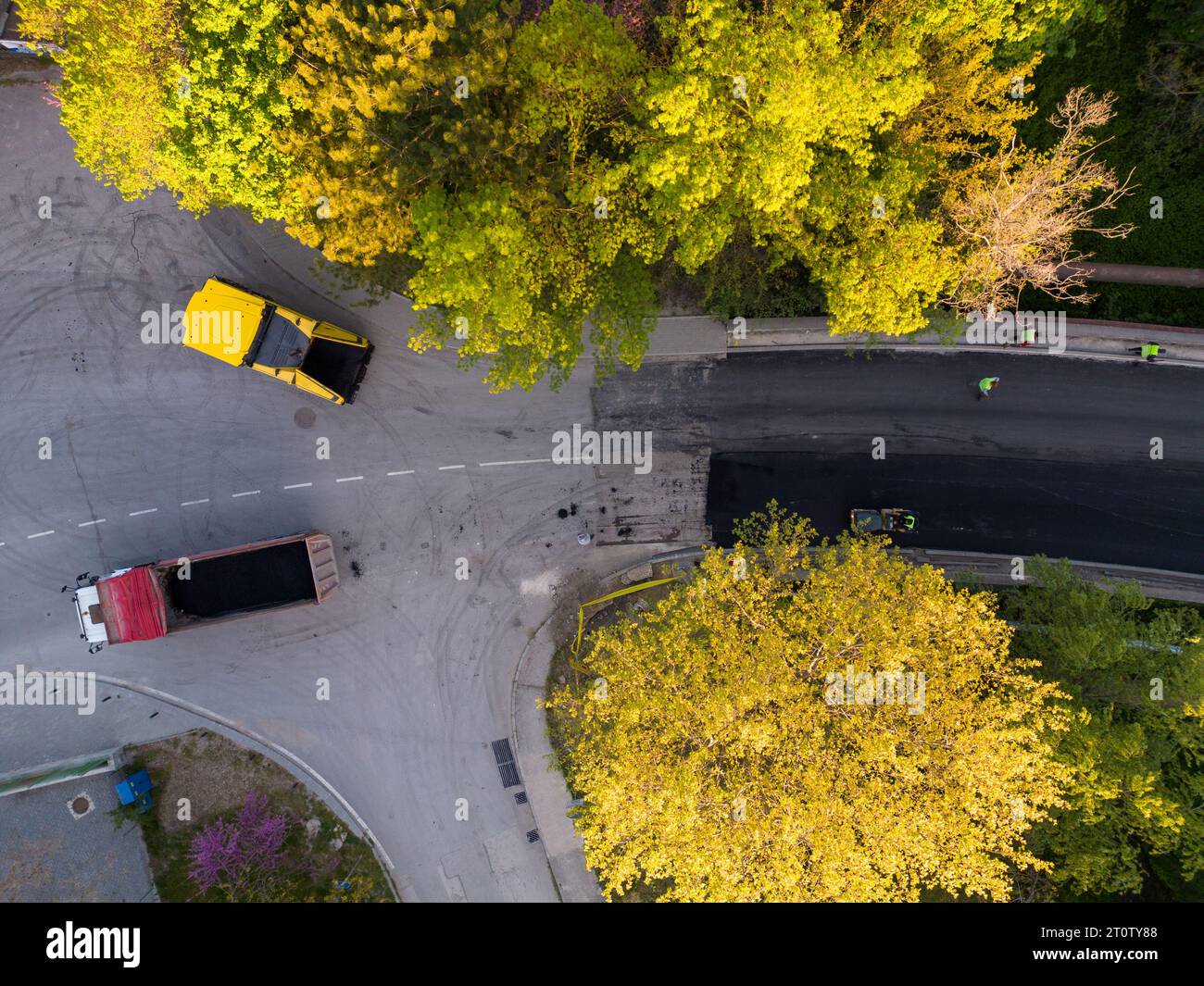 Aerial view of the construction of a new road as asphalt pavers ...