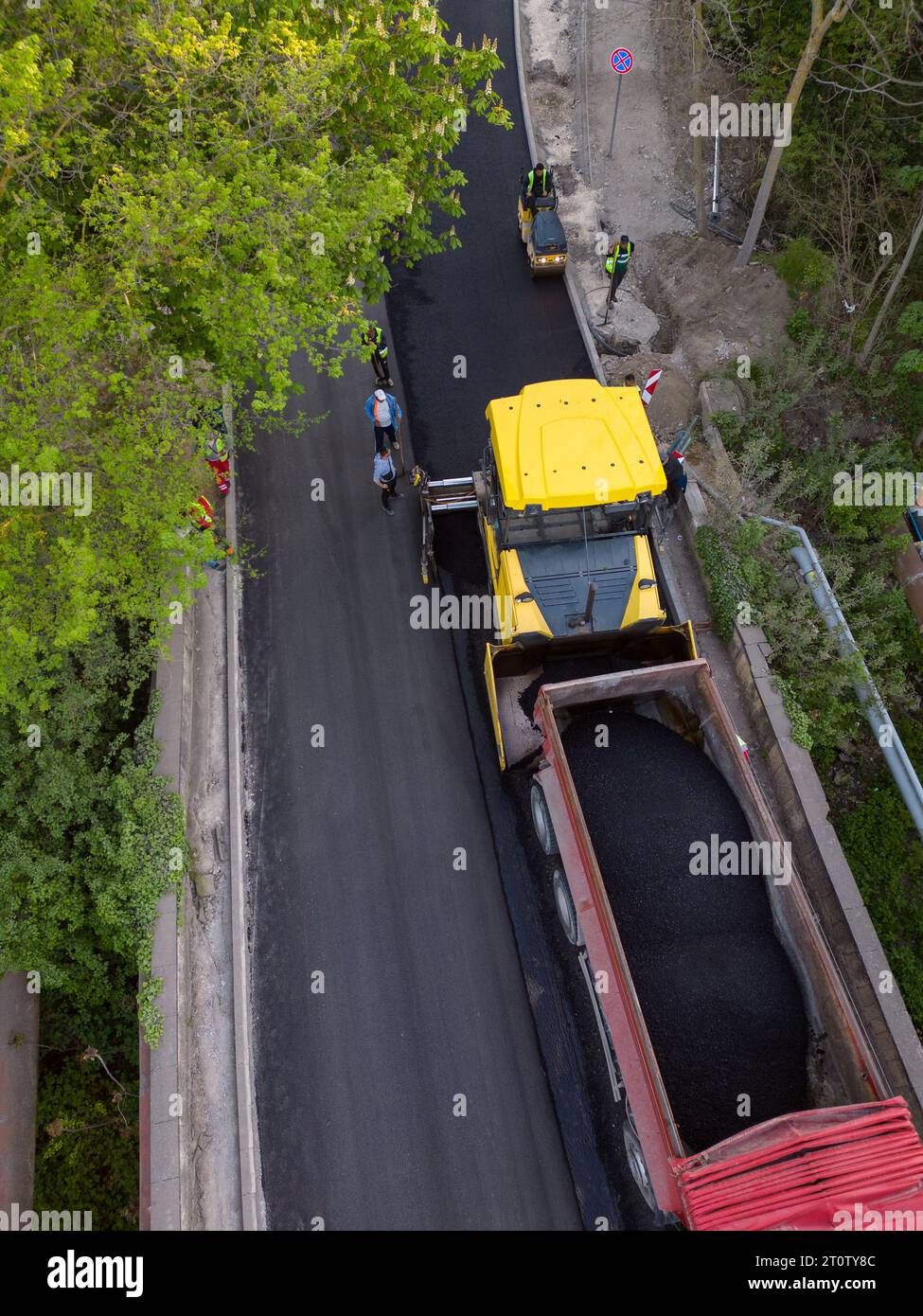 Aerial view of the construction of a new road as asphalt pavers ...