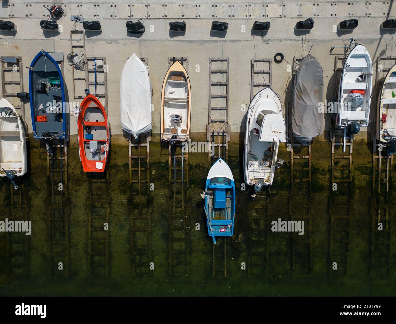 aerial top down view of a serene dock in the sea, with several fishing ...